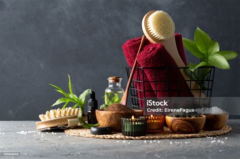 스파와 목욕 컨셉 지상 커피 스크럽 녹차 스크럽 바다 소금 바디 마사지용 오일 바다 돌 수건 및 바디 브러시가 어두운 배경에 있습니다 공간을 복사합니다 수건에 대한 스톡