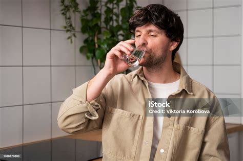 젊은이는 물을 마신다 부엌에서 신선한 물 한 잔을 들고 있는 남자의 초상화 건강 아름다움 및 물 균형의 개념 30 34세에 대한 스톡 사진 및 기타 이미지 Istock