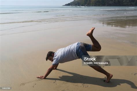 3 발의 아래쪽을 향한 개 를 연습 하는 힌두교 인디언 남자의 이미지 젖은 모래 사장 물의 가장자리 팔로 렘 해변 고아 인도 T