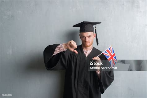 회색 그런 지 이상 젊은 빨간 머리 사람 벽 잡고 성 난 얼굴을 가진 미국된 Kigdom 플래그 거절 된 음수 부호 표시 혐오 거부 개념의 대학원 유니폼 입고 개 개념에