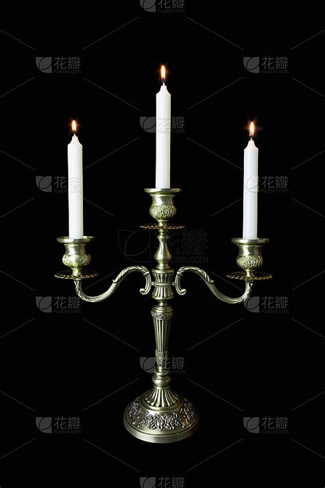 三铜烛台与三根长蜡烛在黑色背景上燃烧