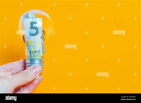 Euro Banknote And Coins Placed Inside A Light Bulb Isolated On Yellow