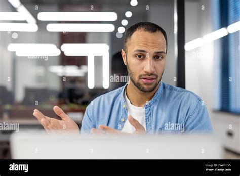 A Professional Businessman In A Modern Office Appears Confused While Staring At His Computer
