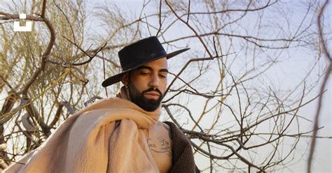 검은 모자와 갈색 스카프를 두른 여자가 낮에 갈색 마른 풀밭에 앉아 있다 사진 Unsplash의 무료 사람의 이미지