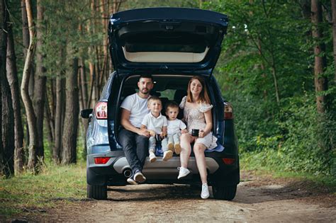 함께 휴가 행복 젊은 가족 여행 자동차로 여행 캠핑에서 자동차 트렁크에 앉아 근처에 귀여운 아이들과 부모 아빠와 엄마 숲 하이킹 전에 다음 여행을 휴식을 위한 피크닉 휴식