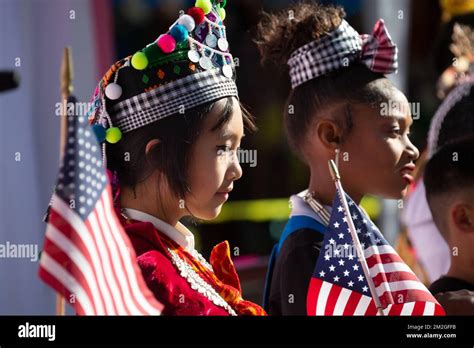 Hmong Youth In Traditional Attire Carry American Flags In The Entry
