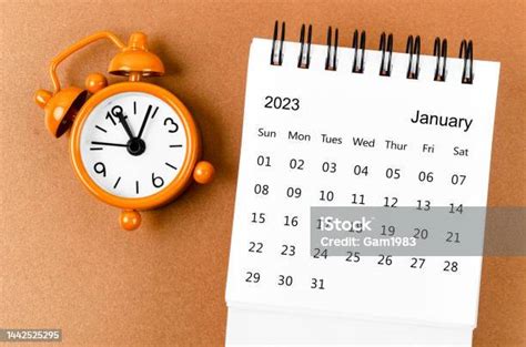 주최자가 노란색 배경에 알람 시계로 2023년을 계획할 수 있도록 2023년 1월 월간 탁상 달력을 닫습니다 0명에 대한 스톡 사진 및 기타 이미지 Istock