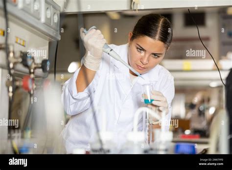 Female Lab Technician Working With Reagents In Test Tubes During Chemical Experiment Stock Photo