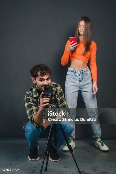 백인 젊은 부부는 스마트폰 카메라와 삼각대가 검은색 배경 위에 격리된 춤 비디오를 만들고 있다 춤추는 비디오 녹화 모든 목적에 적합한 훌륭한 디자인에 영향을 미칩니다