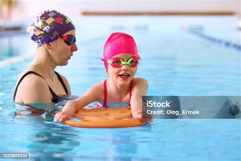공공 수영장에서 플러터 보드 어린 소녀와 함께 수영을 배우는 어머니 또는 코치의 초상화 텍스트 공간 수영 동작 활동에 대한 스톡 사진 및 기타 이미지 Istock