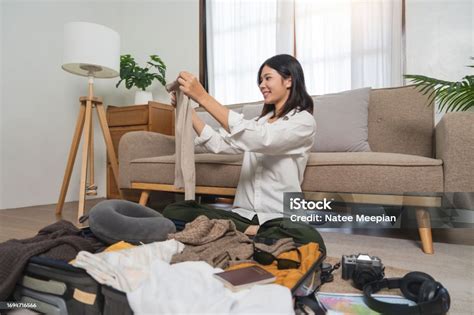 아름다움 아시아 여행자 여자의 초상화는 여름 휴일 주말 여행 여행 집에서 휴가 여행을 위해 여행 가방 여행 가방 수하물에 물건과 의상 옷을 준비합니다 Summer In