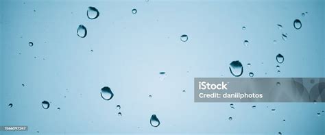 흰색 유리에 빗방울이 있는 최소한의 조명 배경 비오는 물방울이 있는 가벼운 젖은 창문이 푸른 빛으로 근접 촬영됩니다 빗방울이 있는 창 유리의 흐릿한 미니멀리스트 흑백 배경이