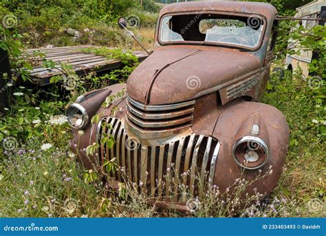 A Rusty 1943 Chevy Truck Overgrown With Weeds In A Junkyard In Idaho