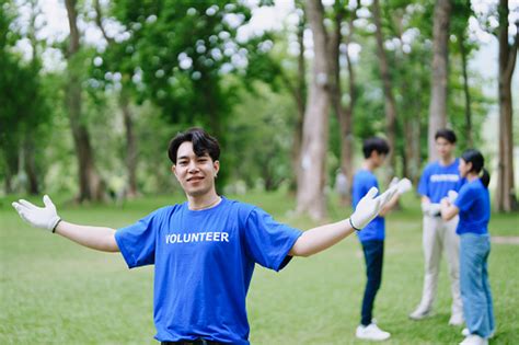 다민족 자원봉사자들은 공원의 오염을 줄이기 위해 재활용할 플라스틱 폐기물을 수거하기 위해 검은색 쓰레기 봉투를 들고 시간을 기부합니다 가방에 대한 스톡 사진 및 기타 이미지