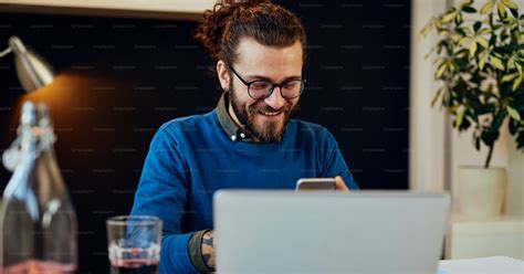 매력적인 백인 수염 난 기업가가 사무실에 앉아 스마트폰을 사용하고 직장에서 휴식을 취하고 있다 사진 Unsplash의 연구 이미지