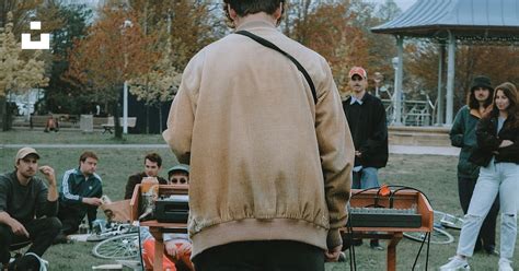 갈색 스웨터와 검은 바지를 입은 남자가 파란색과 빨간색 매트에 서 있다 사진 Unsplash의 무료 이벤트 이미지