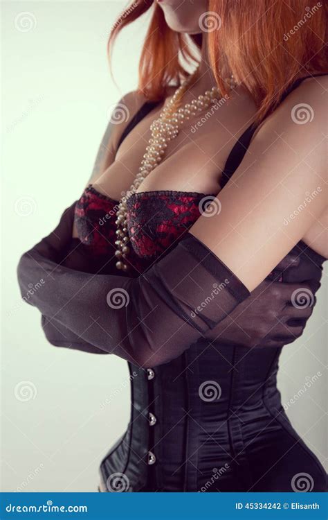 Busty Redhead Woman Wearing Pinup Corset Bra And Sheer Gloves Stock