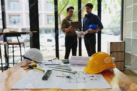 Engineers Discuss Building On Blueprint Drawing Design Building Project In Office Stock Image