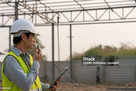검사관 또는 엔지니어가 태블릿을 사용하여 건설 및 품질 보증 새 집을 검사하고 있습니다 엔지니어 건축가 또는 접촉자는 집주인에게 집을 넘겨주기 전에 집을 짓기 위해 일합니다