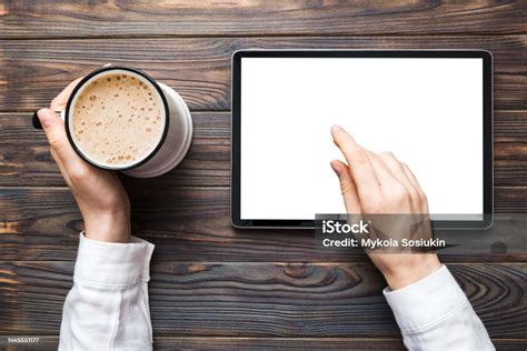 커피 한 잔과 함께 문자 메시지 또는 홍보 콘텐츠 옴 테이블에 대한 빈 복사 공간 화면이 있는 디지털 태블릿을 들고 있는 이미지 여자 손을 닫습니다 빈 태블릿 장치를 들고