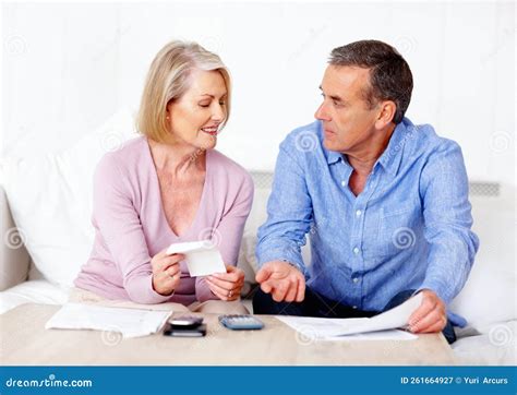 Mature Couple Calculating Expenses Using Calculator At Home Portrait Of A Mature Couple