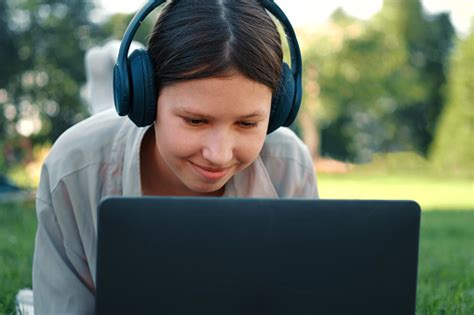 십대 여학생은 야외에 앉아 책 태블릿 공책을 읽고 공부하고 있다 학교로 돌아 가기 대학 운동장이나 공원에서 노트북을 사용하여 푸른 잔디에 누워 있는 여학생 원격 교육 12