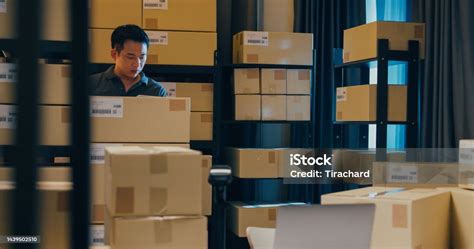 아시아 사업가는 선반에있는 바코드 스캐너 스캔 종이 상자를 사용하고 창고에서 신속한 배달을 위해 디지털 태블릿 컷 재고 온라인 데이터 정보 세부 사항에 데이터를 넣습니다