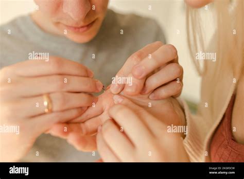 Man Removing Splinter From Woman S Hand At Home Stock Photo Alamy