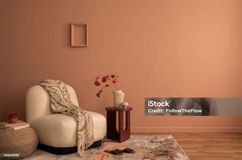 모의 포스터 프레임 베이지 색 안락 의자 둥근 베개 세련된 램프 무늬가있는 깔개 말린 꽃이있는 꽃병 및 개인 액세서리가있는 거실