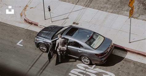 검은 가죽 재킷과 검은 바지를 입은 남자가 낮에 도로에서 검은색 세단 옆에 서 있다 사진 Unsplash의 무료 회색 이미지