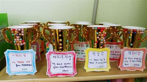 There Are Many Cups On The Table With Name Tags In Front Of Them And Some Writing On Each One