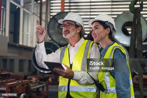 프로젝트 관리자와 엔지니어는 공작물을 검사하고 공장의 제품 및 안전에 대한 표준 및 안전성을 확인합니다 기술자와 여성 노동자가 공장에서 회의에 대해 이야기하고 있다 2명에