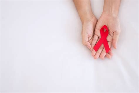 Premium Photo Man Holding Red Ribbon For Supporting People Living And Illness Healthcare And