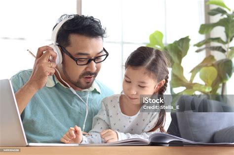 아버지는 귀여운 딸에게 학교 숙제를 가르치고 집에서 E러닝 공부를 위해 노트북 컴퓨터를 사용하고 행복한 가족 아빠와 아이는