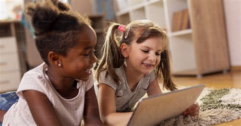 놀이방 바닥에 누워 태블릿 컴퓨터에서 게임을 하고 즐거운 시간을 보내는 두 어린 소녀의 높은 각도 보기 사진 Unsplash의 세르비아 이미지