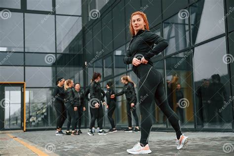 Redhead Is Standing Against Her Friends Group Of Sportive Women Is