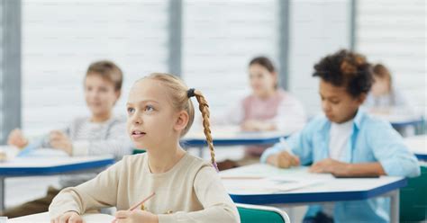 금발 머리를 가진 호기심 많은 어린 소녀가 학교 책상에 앉아 선생님의 말을 듣고 있다 가로 초상화 복사 공간 사진 Unsplash의 퀴즈 이미지