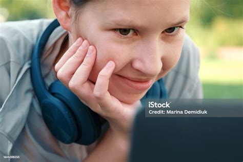 십대 여학생은 야외에 앉아 책 태블릿 공책을 읽고 공부하고 있다 학교로 돌아 가기 대학 운동장이나 공원에서 노트북을 사용하여