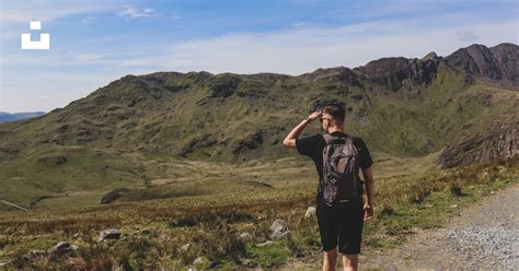 산 꼭대기에 서있는 남자 사진 Unsplash의 무료 의복 이미지