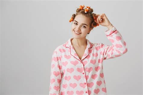 Милая девушка в пижаме применяет бигуди для волос Бесплатно Фото