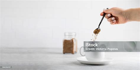 한 여성이 회색 돌 테이블에 흰 찻잔에 인스턴트 커피를 추가합니다 공간을 복사합니다 가루로 빻은에 대한 스톡 사진 및 기타