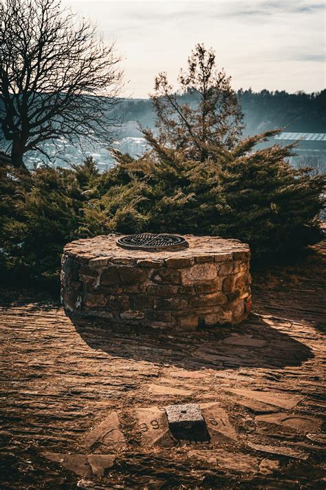 고요한 풍경 속의 역사적인 돌 우물 · 무료 스톡 사진