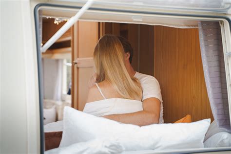 젊은 그냥 캠핑카 바퀴에 집 트레일러 모터 홈에서 여행하는 부부와 결혼했습니다 낭만적 인 도로 여행 자유 생활을 사랑하십시오 작은 침대 밴의 침실 방랑욕 휴가 주말 소녀