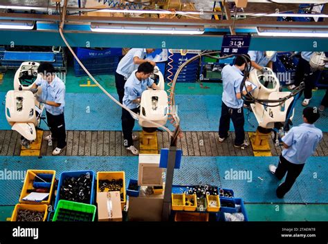 Workers Assemble Vespas On The Assembly Line At The Piaggio Factory Outside Hanoi Vietnam Stock