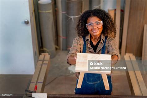 아시아 목수 여성은 나무 의자를 들고 공장 작업장에서 이 목재 제품을 생산하기 위해 마친 후 평면도로 카메라에 선물합니다 20 24세에 대한 스톡 사진 및 기타 이미지