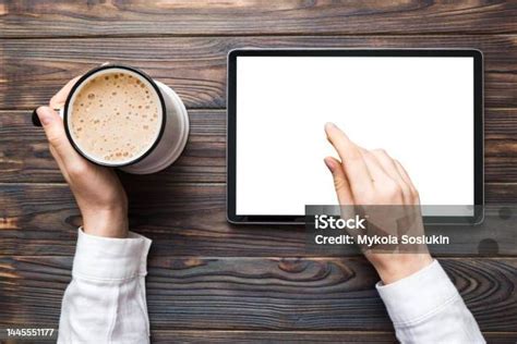 커피 한 잔과 함께 문자 메시지 또는 홍보 콘텐츠 옴 테이블에 대한 빈 복사 공간 화면이 있는 디지털 태블릿을 들고 있는 이미지 여자 손을 닫습니다 빈 태블릿 장치를 들고