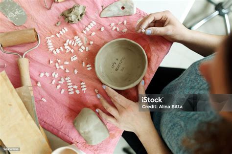 여성 손의 클로즈업 이미지는 점토와 함께 작동하여 미래의 세라믹 플레이트 현대 도자기 작업장에서 손 건물의 클래스 창의적인