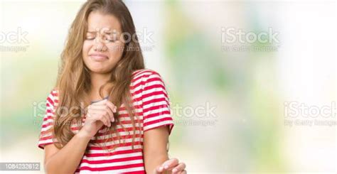 젊은 아름 다운 갈색 머리 여자 입고 격리 된 배경 위에 T셔츠 줄무늬 식 불쾌 하 고 무서운 혐오 때문에 역 겨 운 얼굴을 하 고 혐오 반응 손으로 발생합니다 성가신