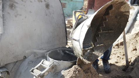 Worker At A Construction Site Mixes The Mortar For Floor Screed In A