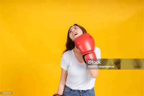 초상화 행복 한 젊은 아시아 여자 와 권투 장갑 자기 사업 노크 펀치 히트 에 흰색 티셔츠 노란색 배경 고립 된 스튜디오 샷 및 복사 공간 Championship에 대한